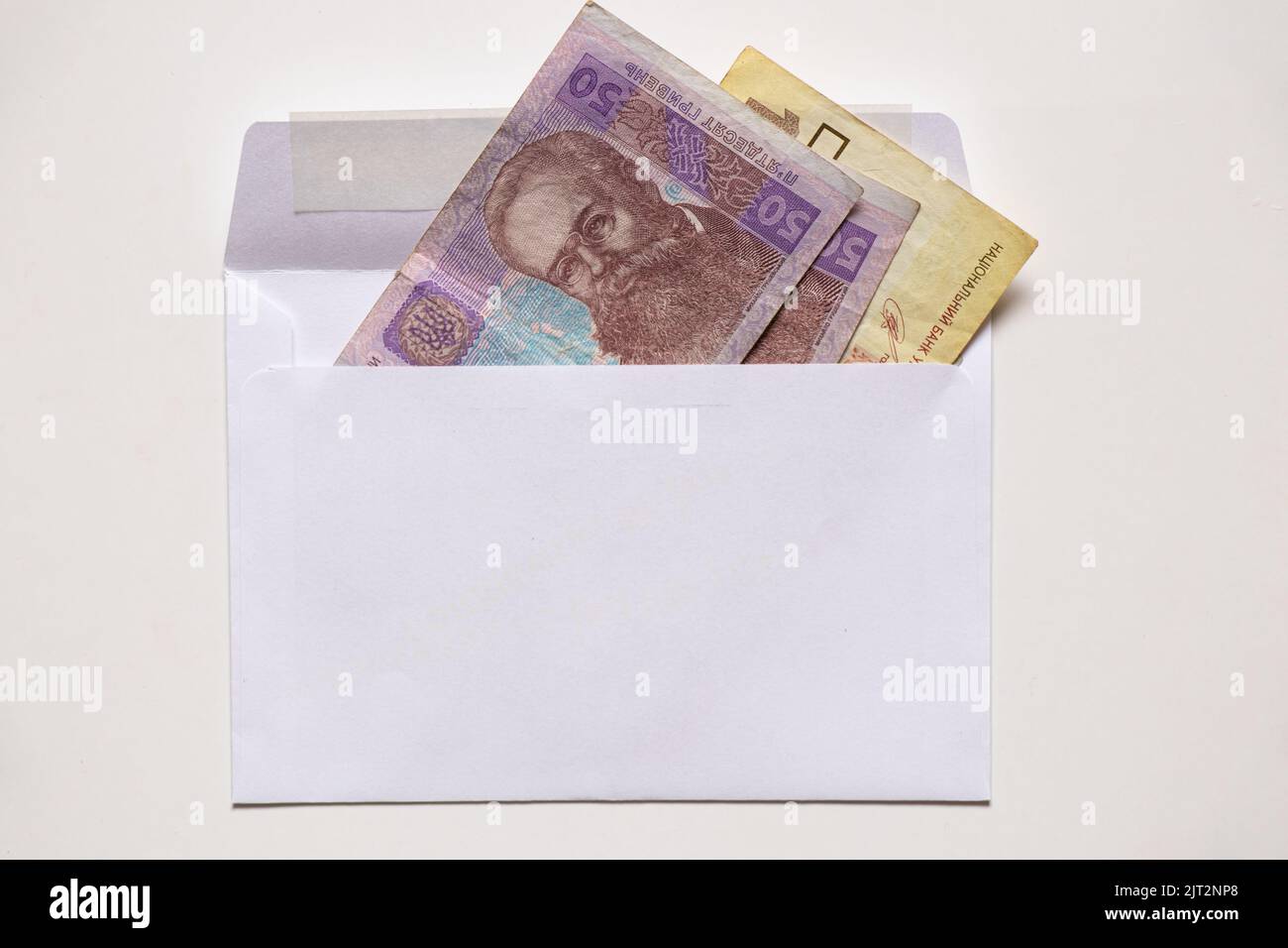 Ukrainian 50 and 100 UAH lie in a white envelope on a white background ...