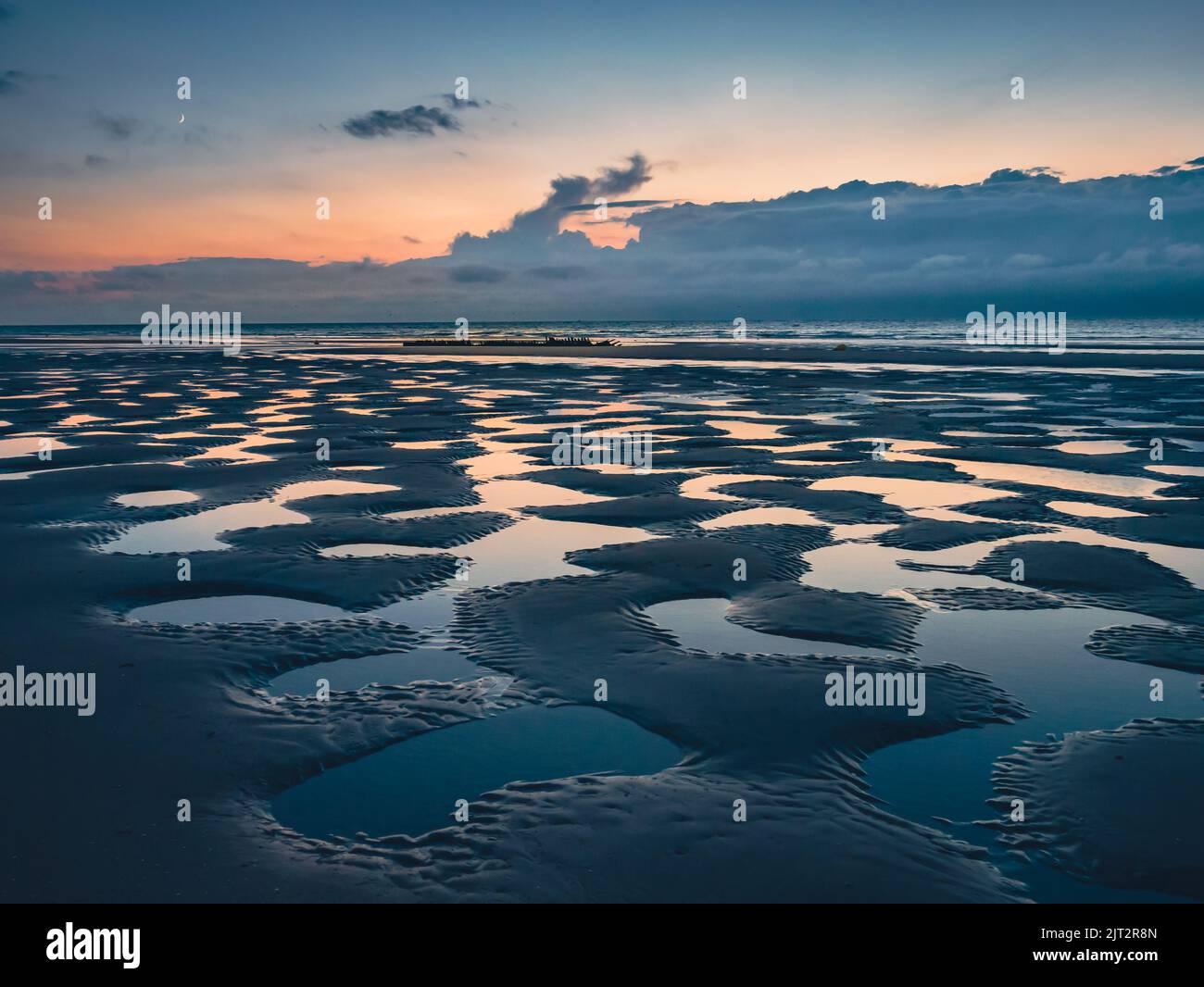 Small water puddles giving way to a shipwreck at low tide Stock Photo ...