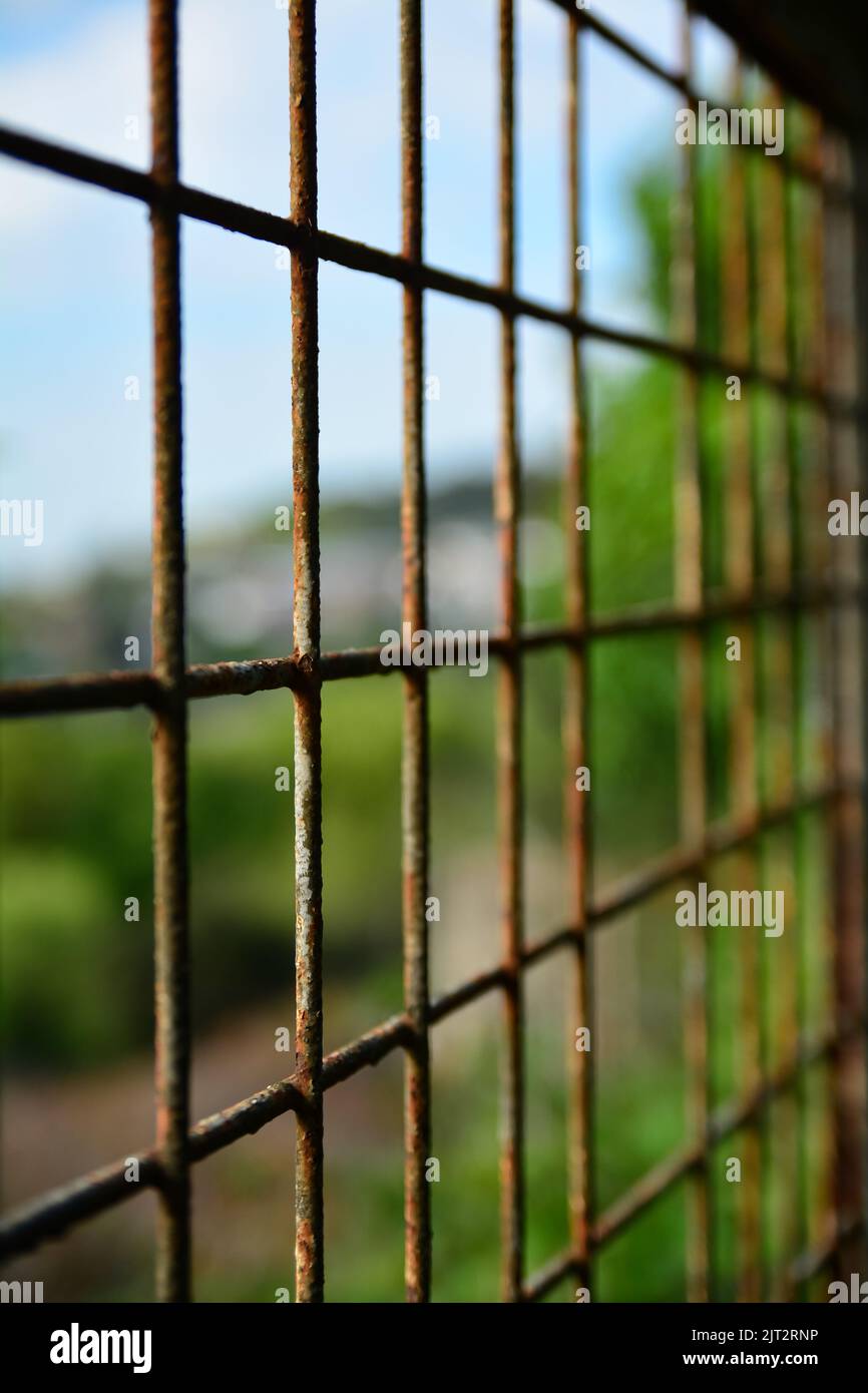 City view between rusty iron bars, iron mesh Stock Photo - Alamy