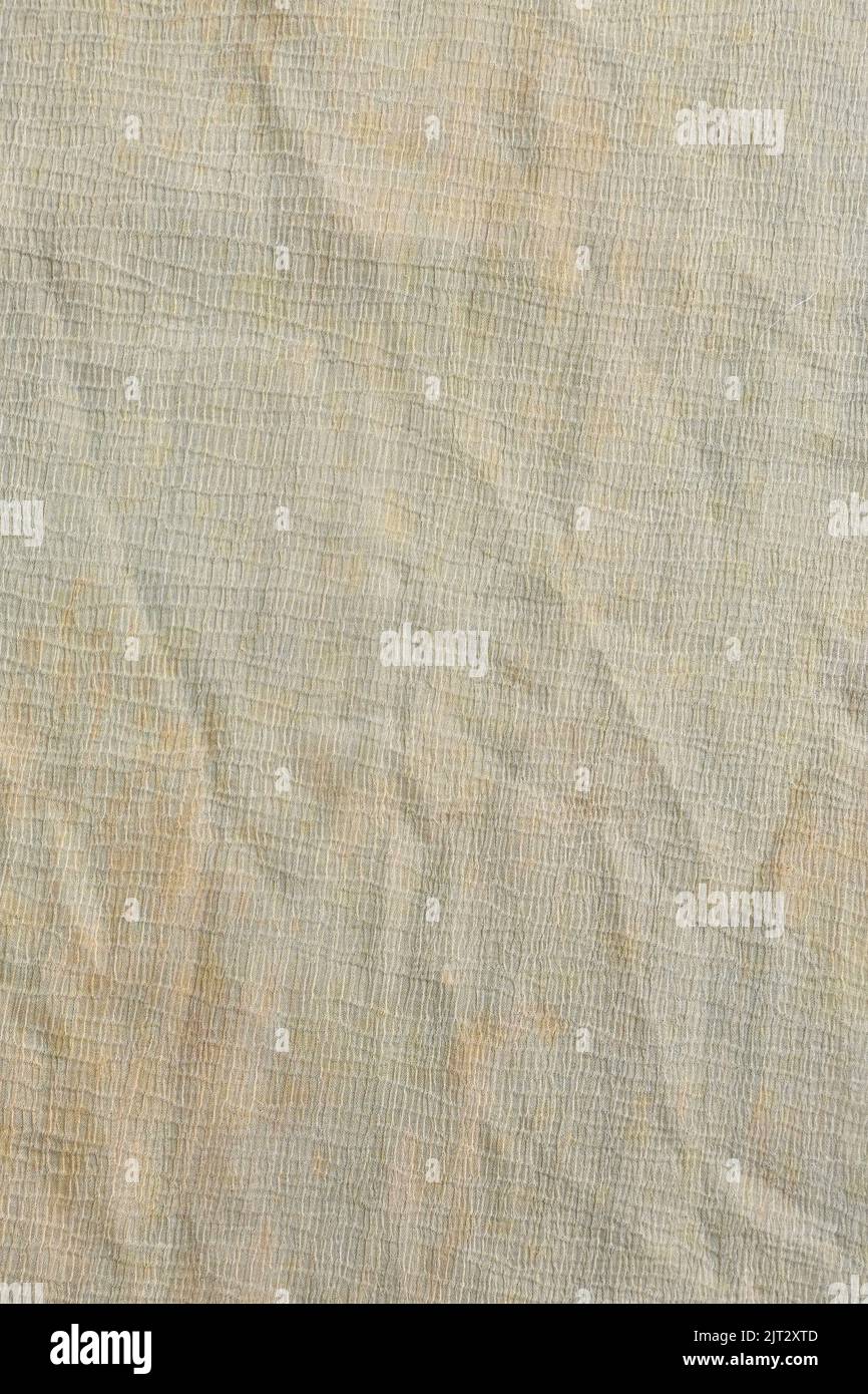 A vertical shot of a wrinkled, cream-colored piece of cloth - weathered ...