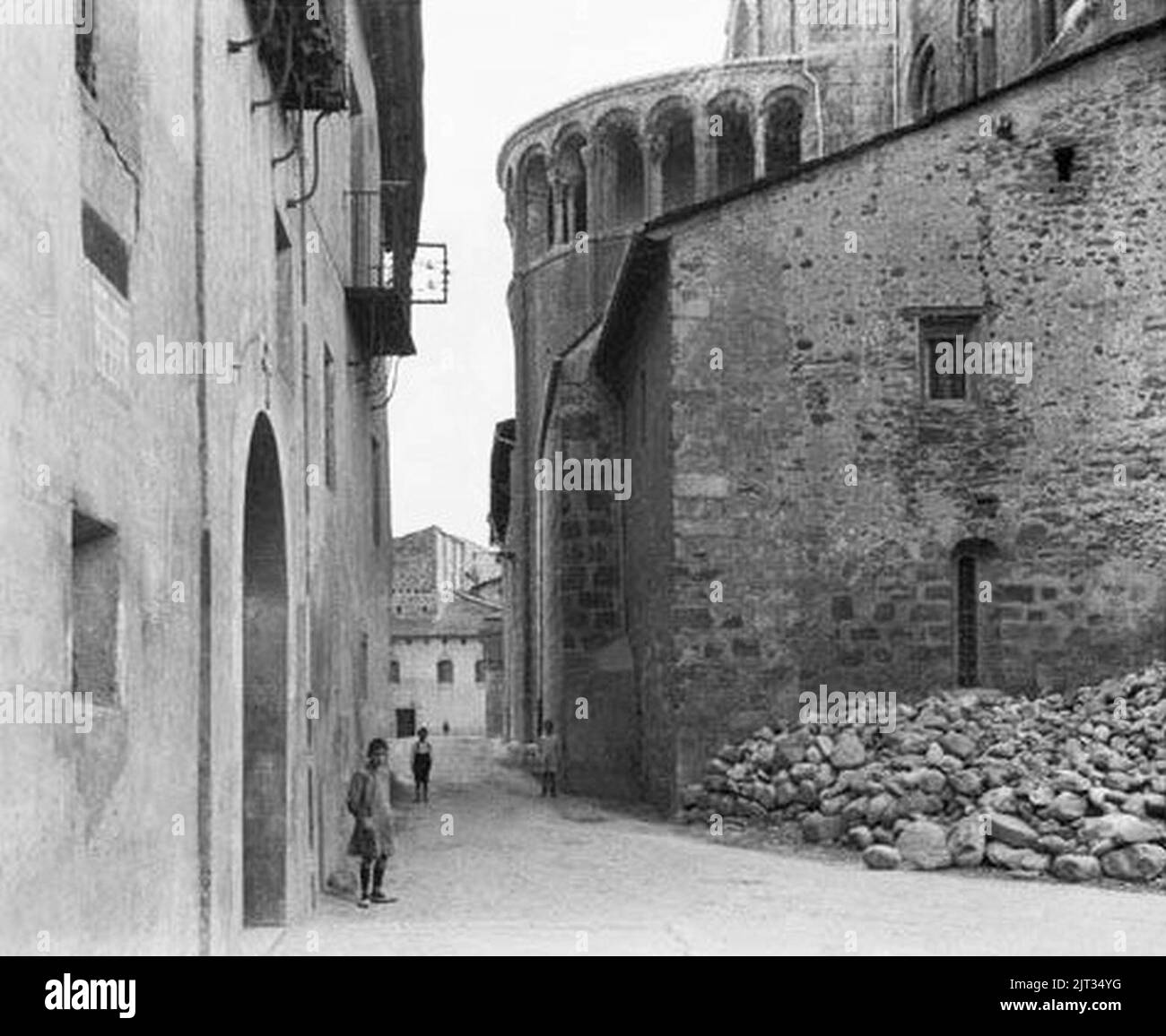 Tres nens pel carrer a la Seu d'Urgell, al costat de l'església ...