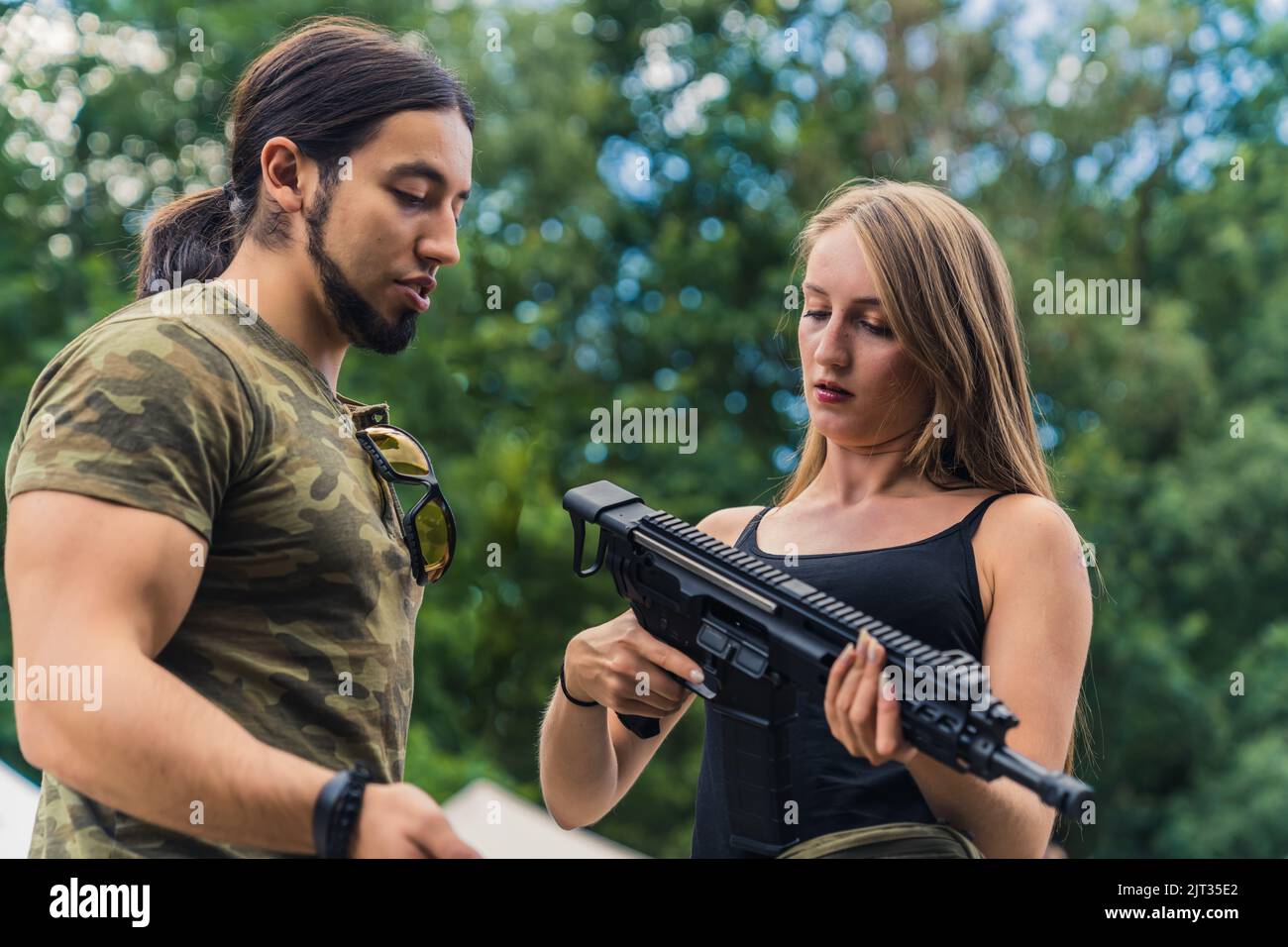 Male caucasian muscular shooting instructor in moro t-shirt showing the ...