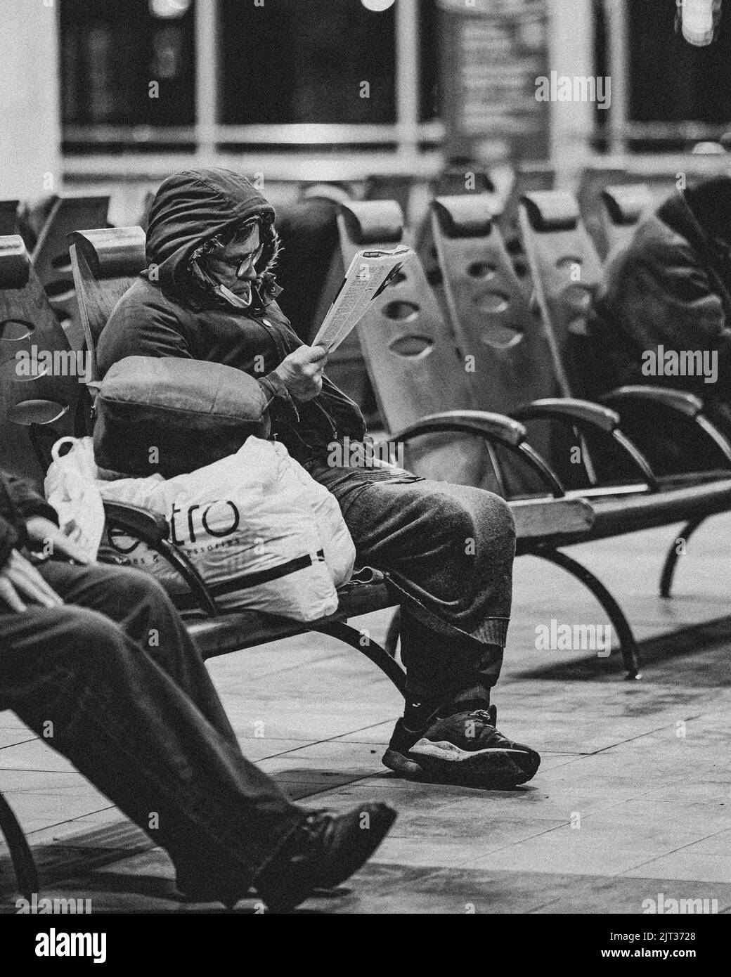 A closeup grayscale shot of sleeping homeless men in the station Stock ...