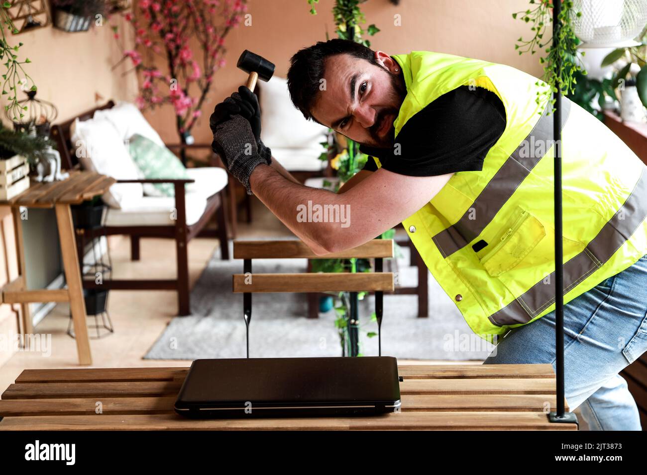 An angry male worker in a uniform with a hammer Stock Photo - Alamy