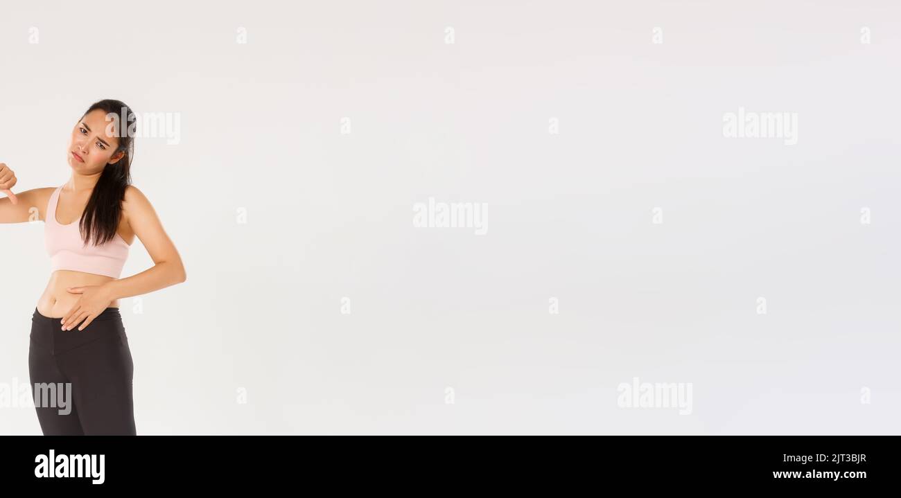 Full length of disappointed, gloomy and sad cute brunette fitness girl ...