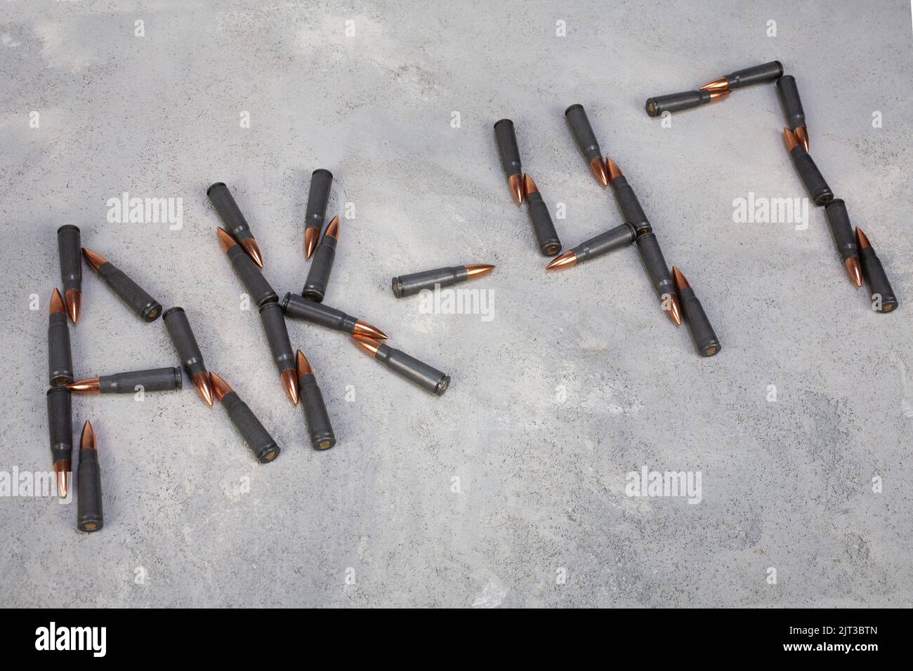 kalashnikov ak 47 word from 7,62 mm bullets on grey concrete surface ...