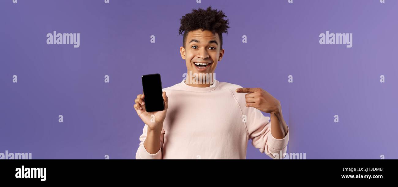 Portrait of excited, happy smiling man talking about new application or ...