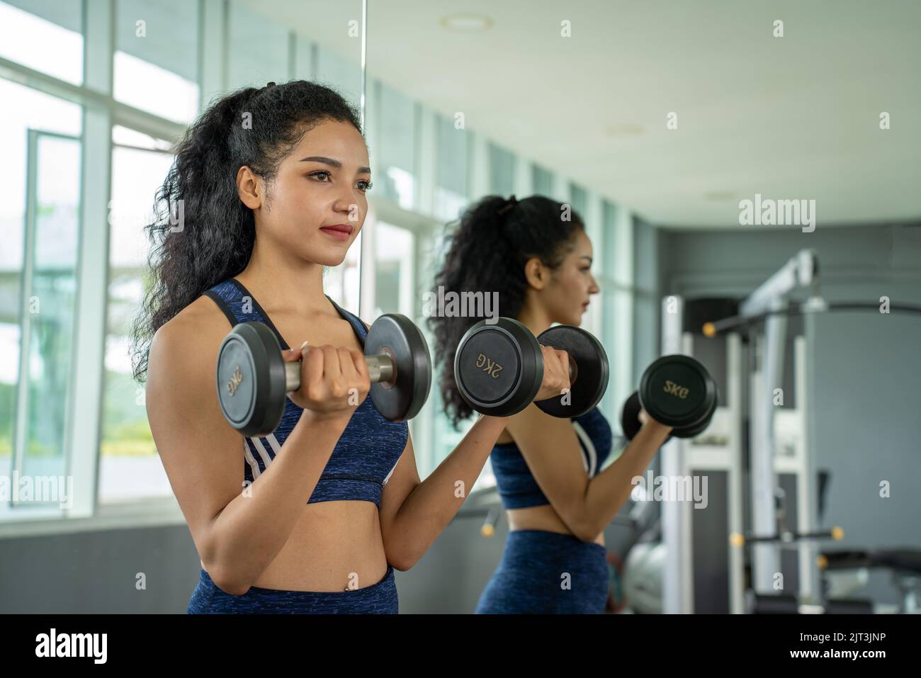 Beautiful young Girl weight training with dumbbells at Gym. Sport ...