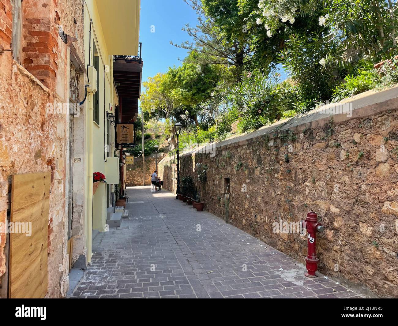 A narrow, paved walkway in Chania, Crete, Greece with old buildings and ...