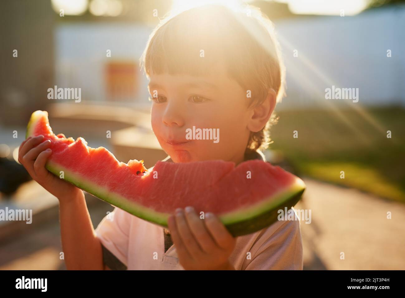 Sweet tastes of summer. an adorable little boy eating a slice of ...