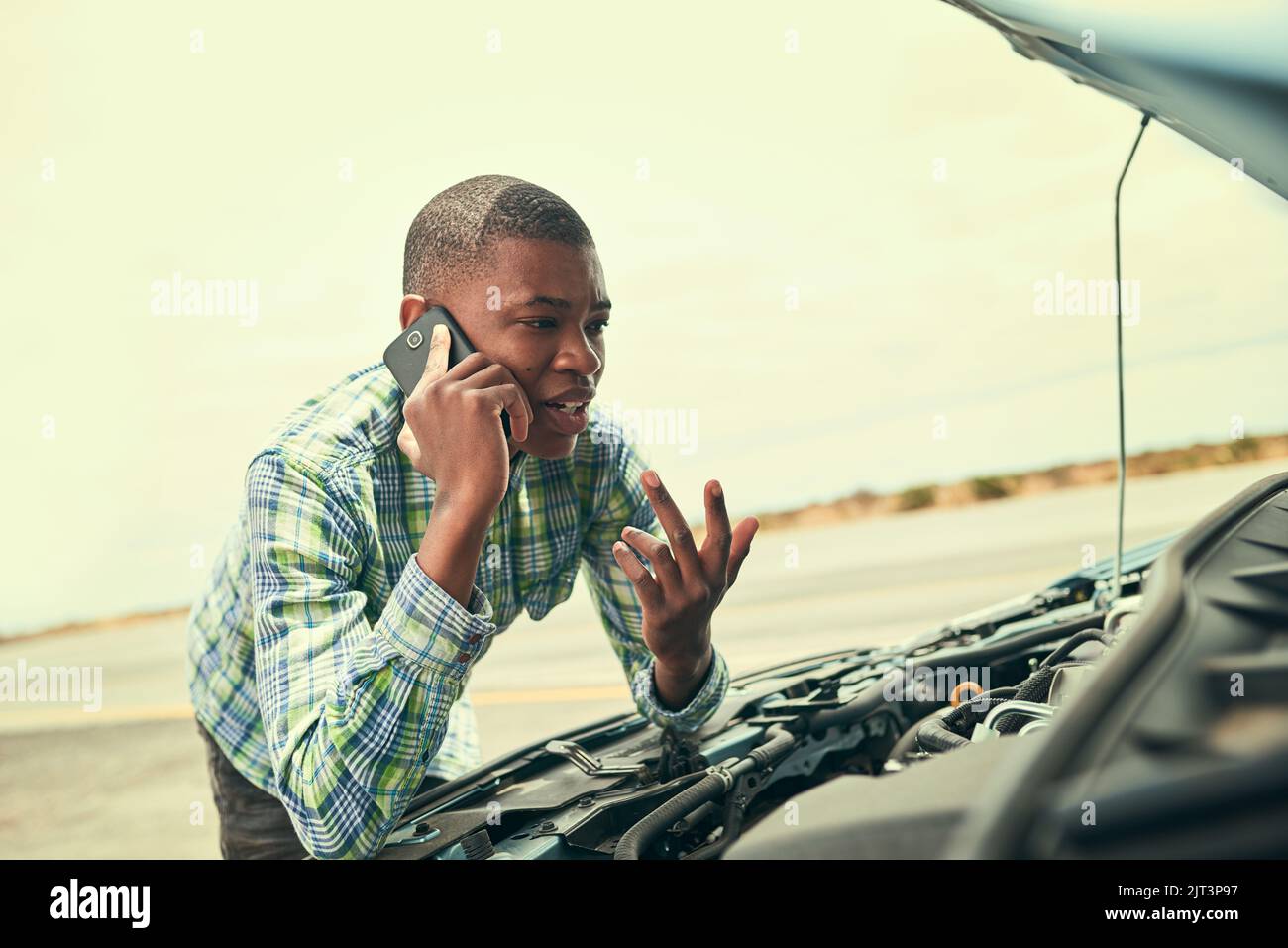 That long. a young man calling roadside assistance after breaking down Stock Photo - Alamy