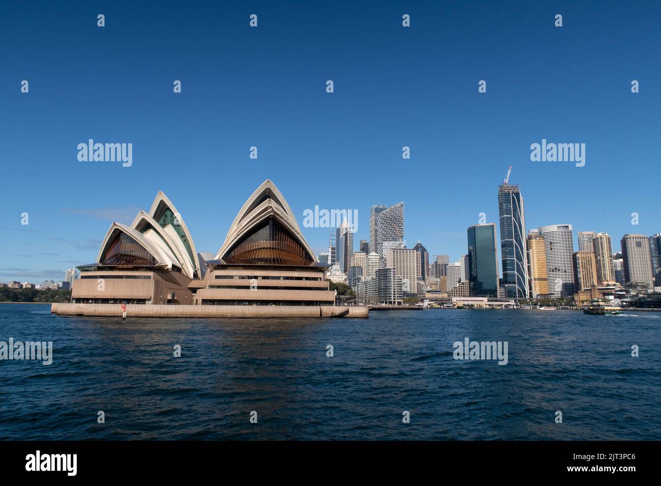 The Sydney Opera House as seen from the water on a beautiful blue sky ...
