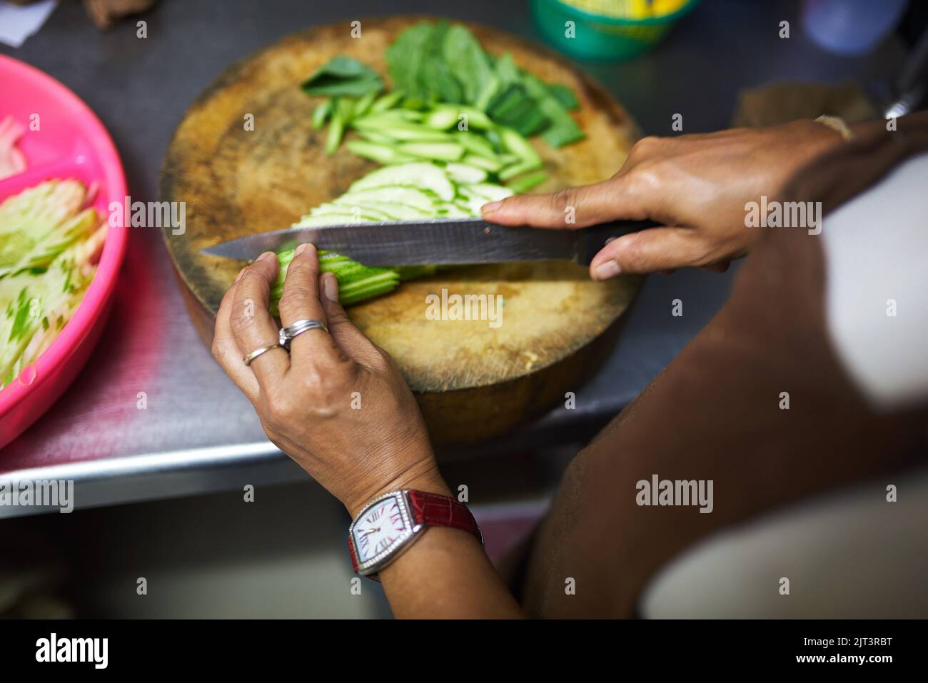 Slicing and dicing. an unidentifiable chefs hands as she cuts ...