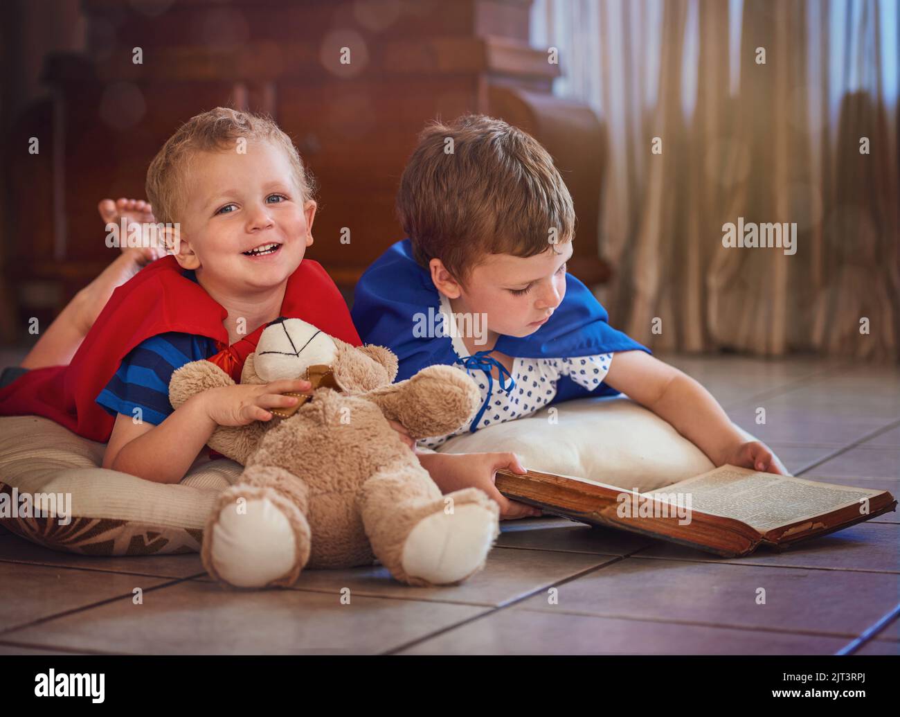 Sparking their imaginations at story time. Portrait of a happy little ...