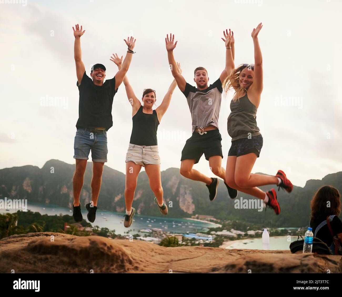 Reach for the sky. a happy young couple jumping in front of an island ...