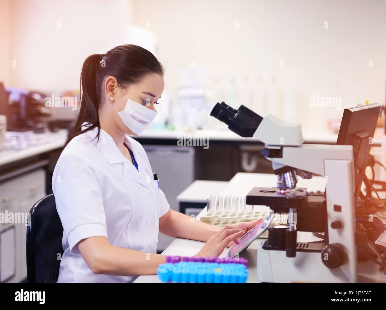 The lab expert at work. a young scientist using a digital tablet while ...