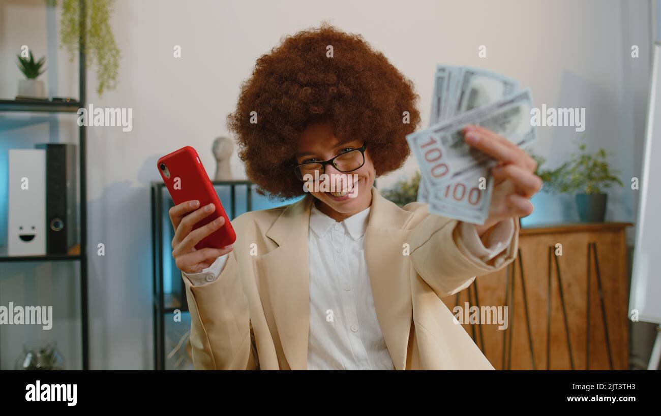 Rich business woman working on smartphone counting money cash ...