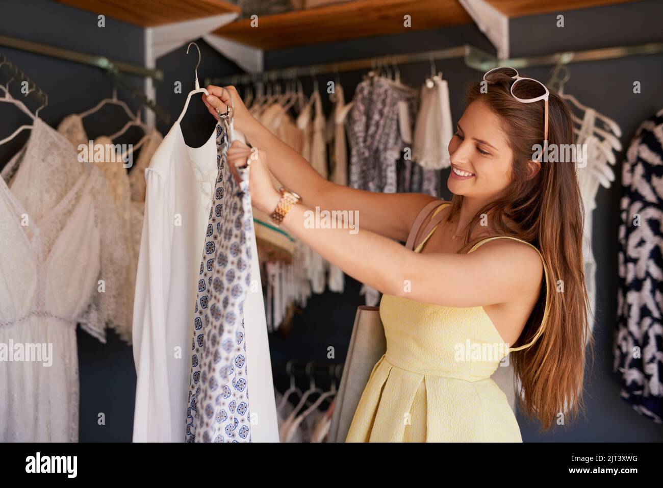 Ill go with this one. a young woman browsing through the clothes in a ...