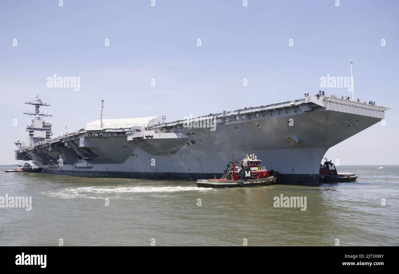 Tug boats maneuver Gerald R. Ford into the James River during the ship ...