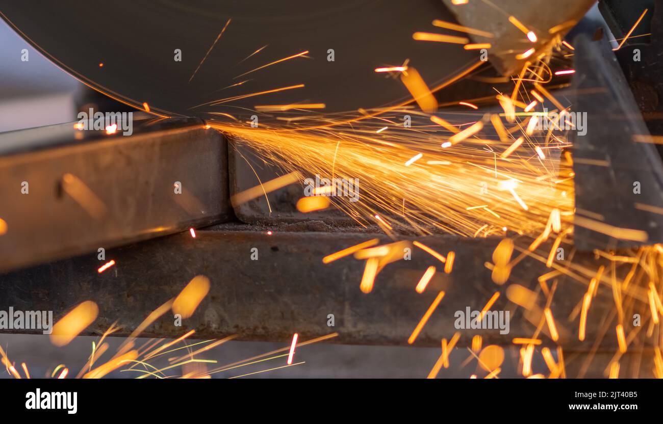 Worker cutting steel rectangular pipe in construction site Stock Photo ...