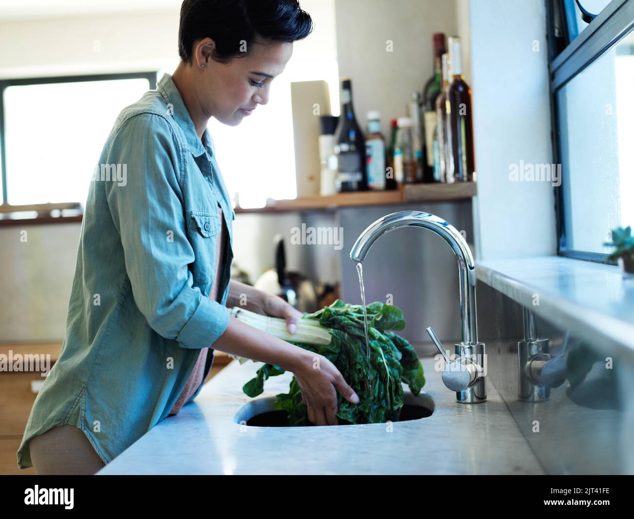 Only the freshest and cleanest for her. a young woman washing ...