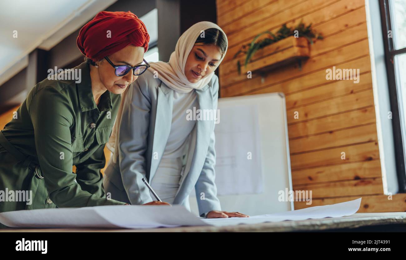 Two Muslim architects working together on a creative project in an ...