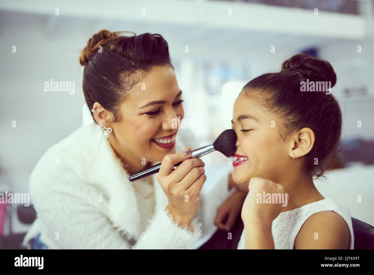 Dressing room smiles. a mother applying makeup to her cute little girl in a dressing room Stock ...