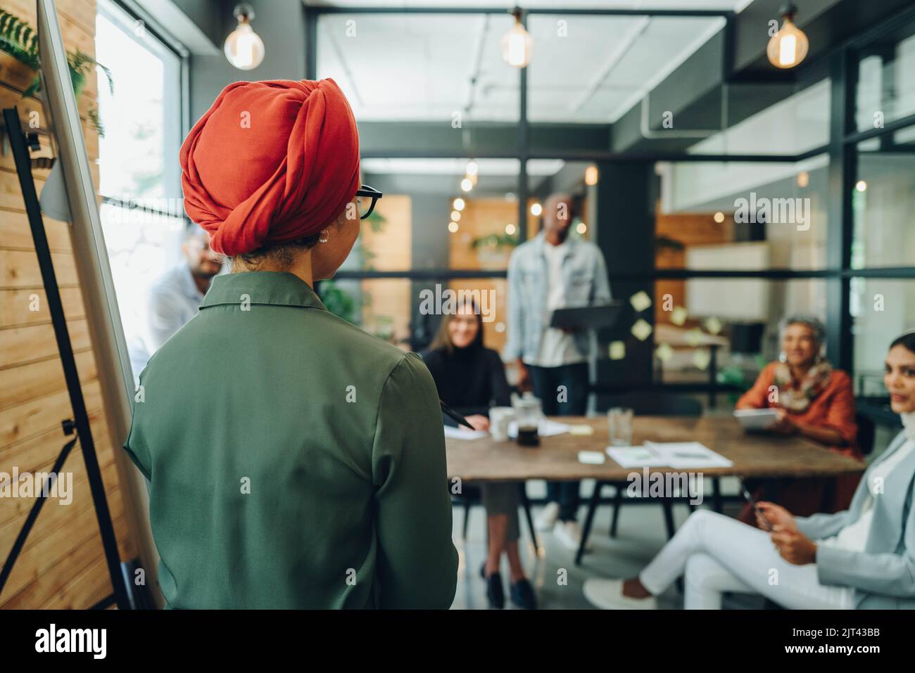 Team leader giving a speech during a boardroom meeting. Muslim ...