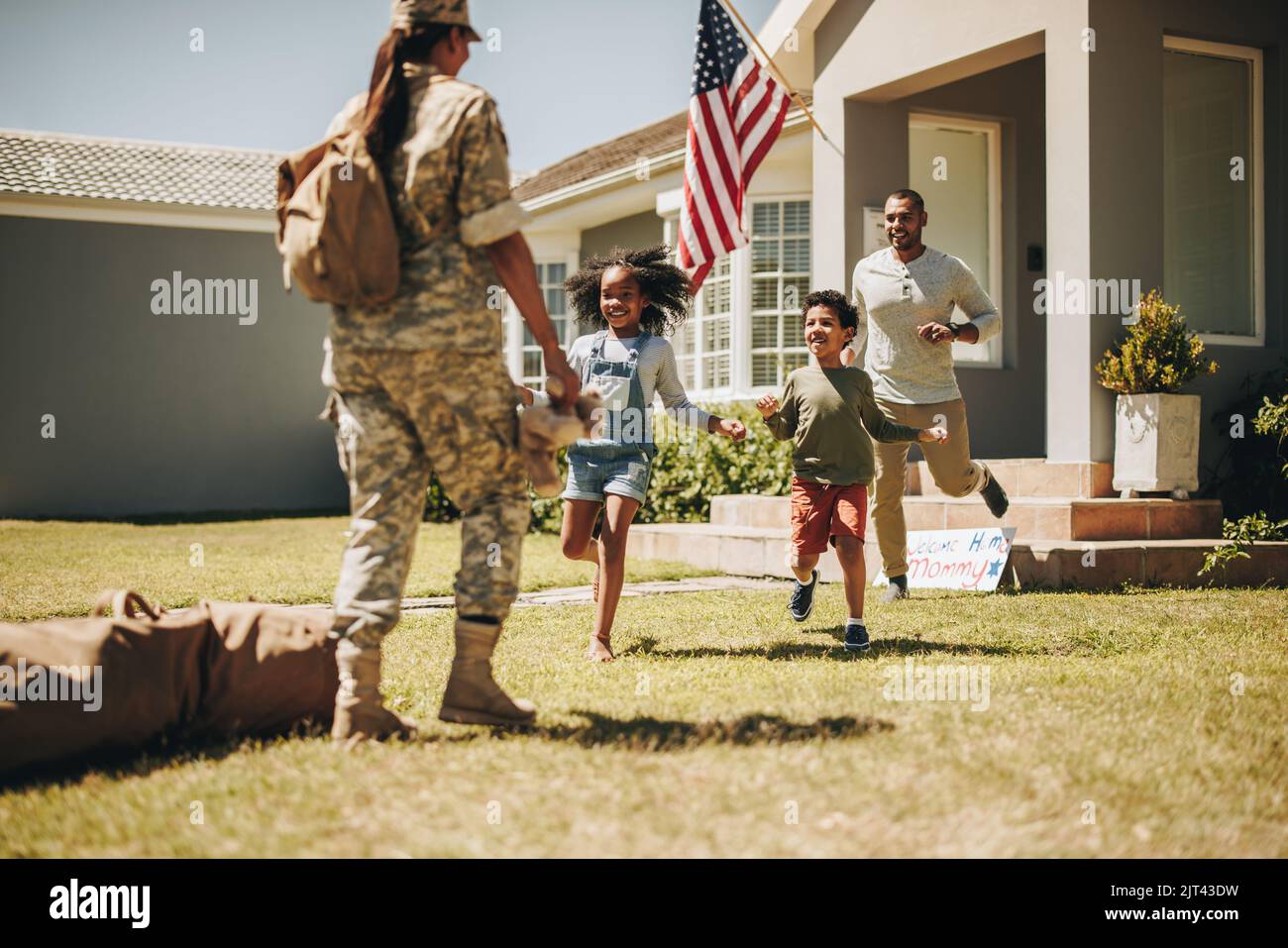 Military woman receiving a warm welcome from her husband and kids ...
