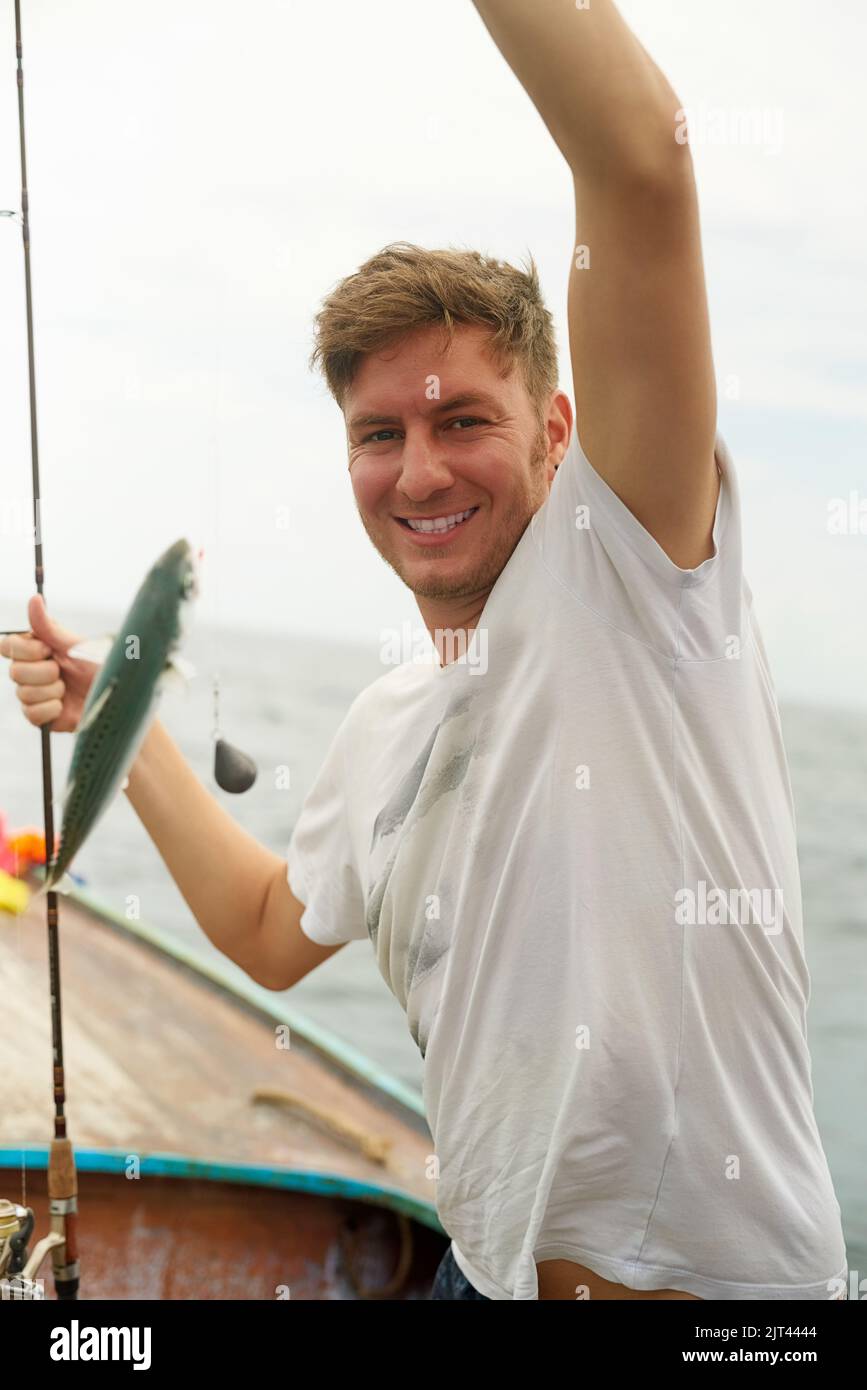 Every catch counts. Cropped portrait of a handsome young man fishing ...