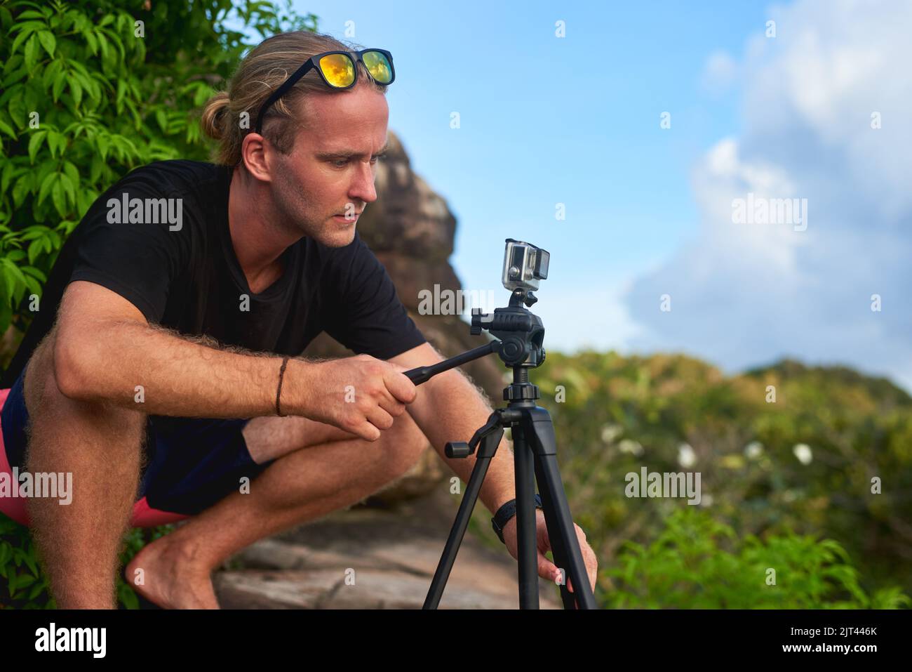 Setting up to shoot a time lapse. a young man using his camera outside ...