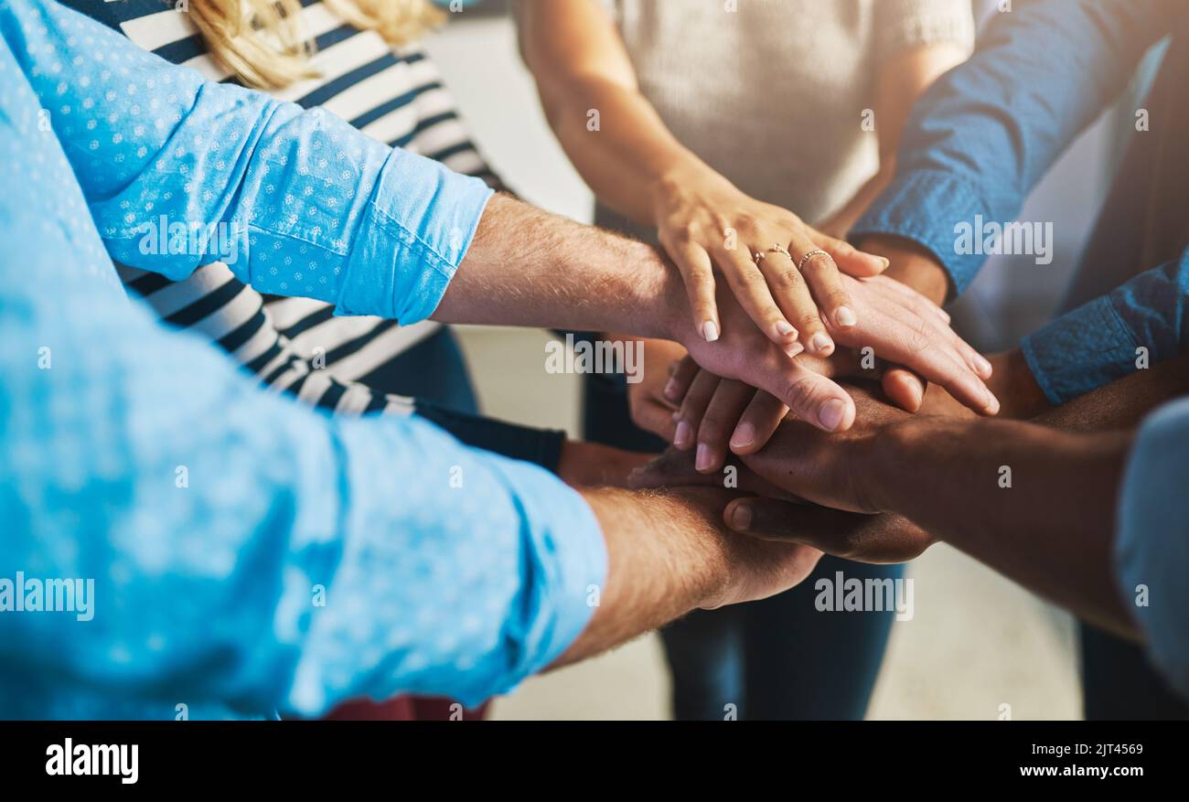 Go team. a group of creative businesspeople standing with their hands ...