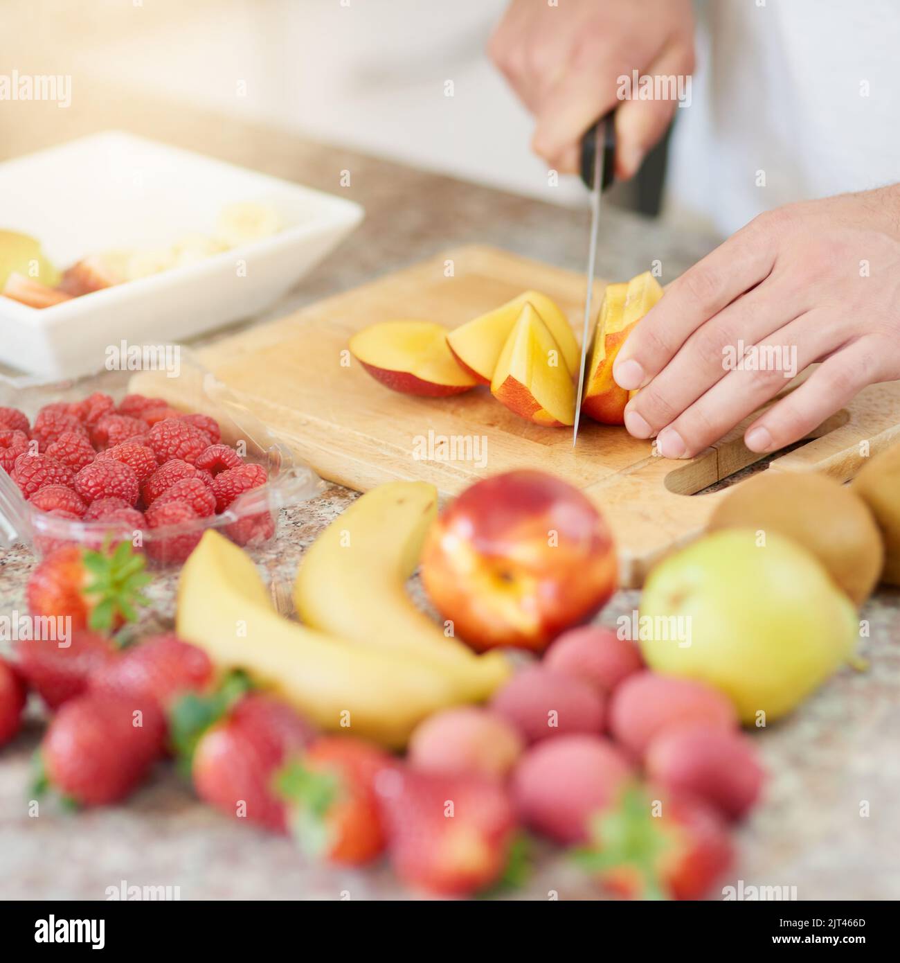I eat good to feel good. a young man making a fruit salad in his ...