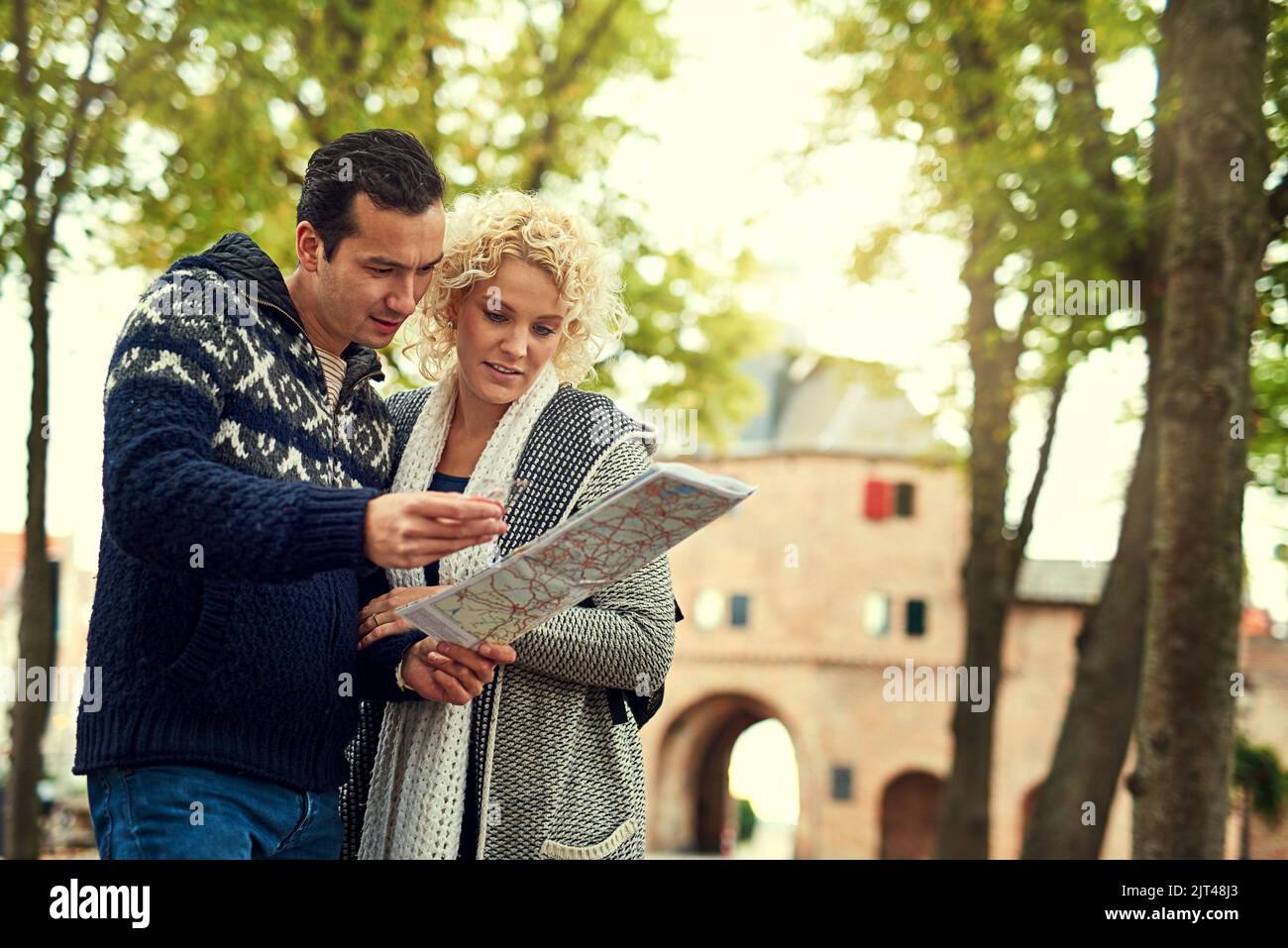 Where to next. a young couple looking at a map while on vacation Stock ...