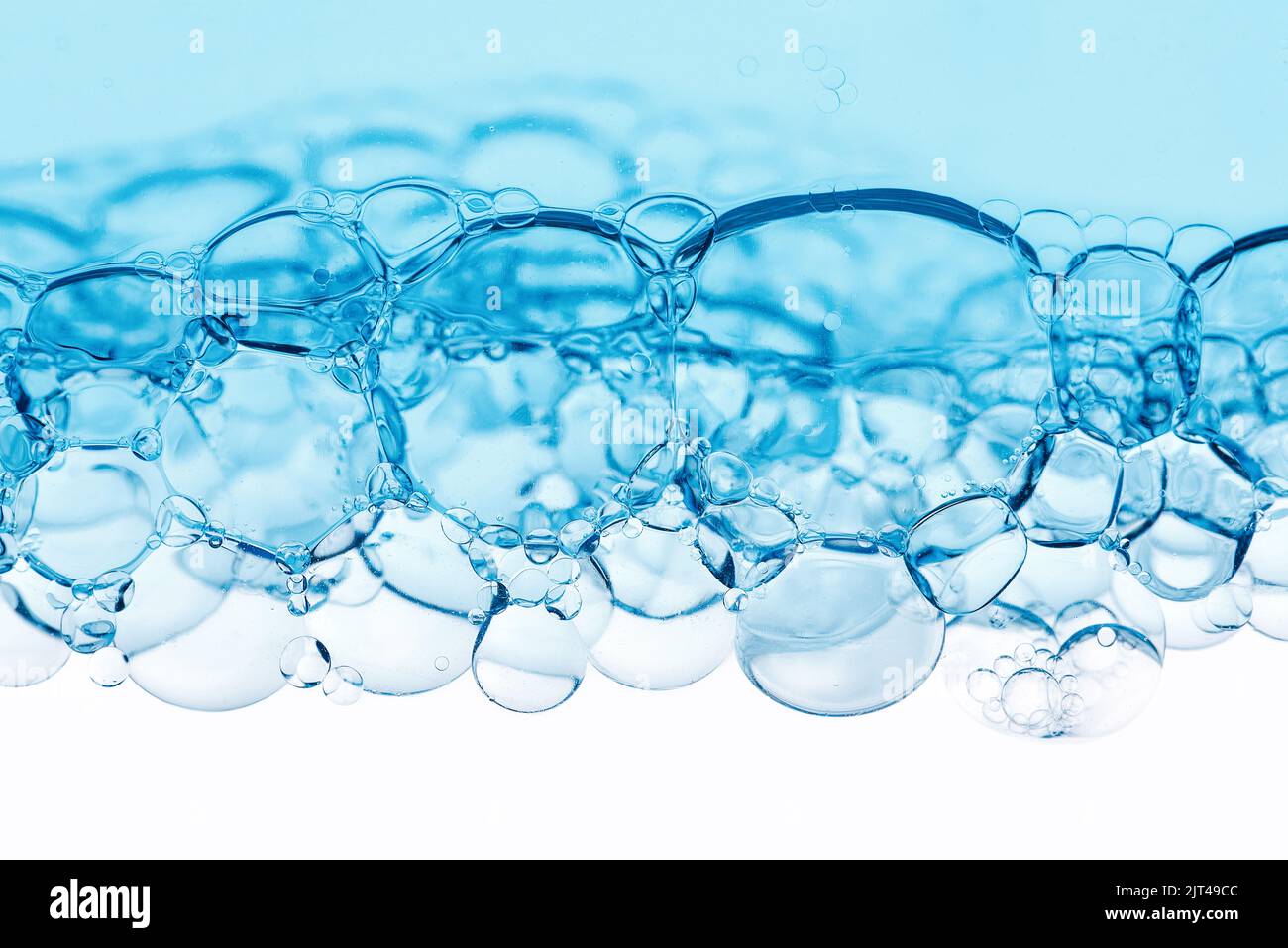 Transparent blue bubbles of different sizes on a white background ...