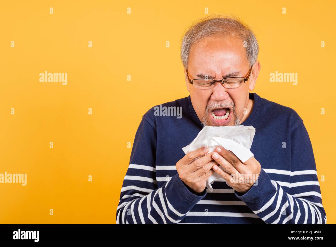 Portrait senior old man blowing nose with tissue studio shot isolated ...