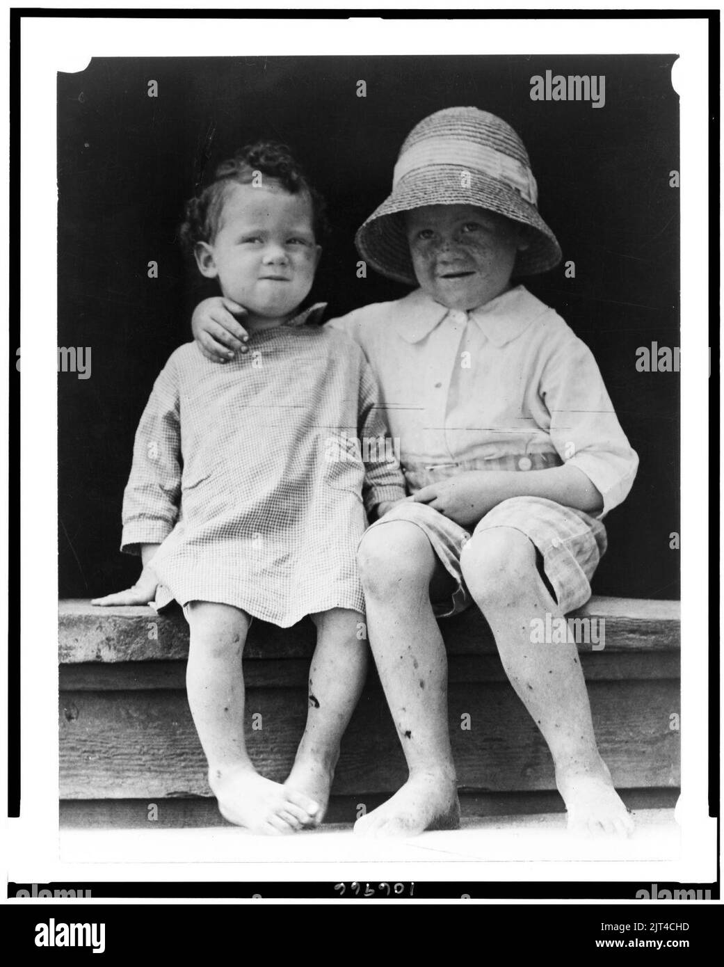 Two children, seated on step, facing front Stock Photo - Alamy