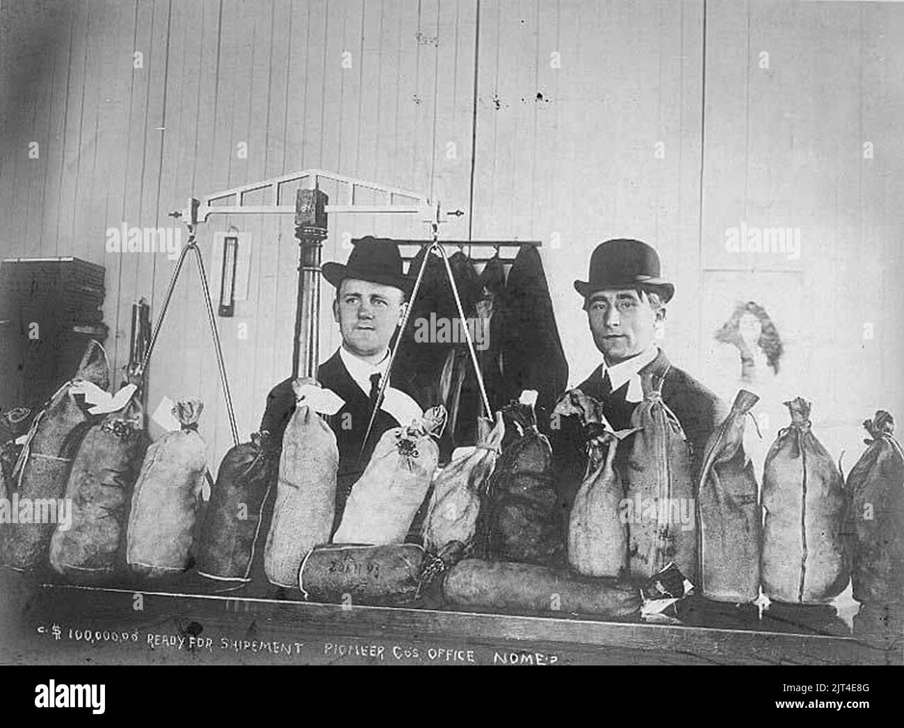Two men with bags of gold and a scale, Pioneer Company office, Nome ...