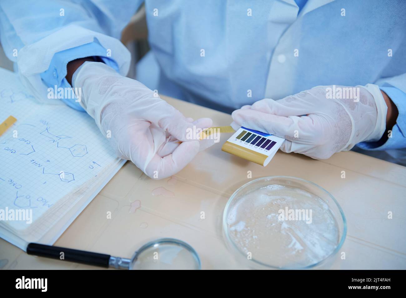 Hands of lab assistant using litmus paper conduct PH test, measuring ...