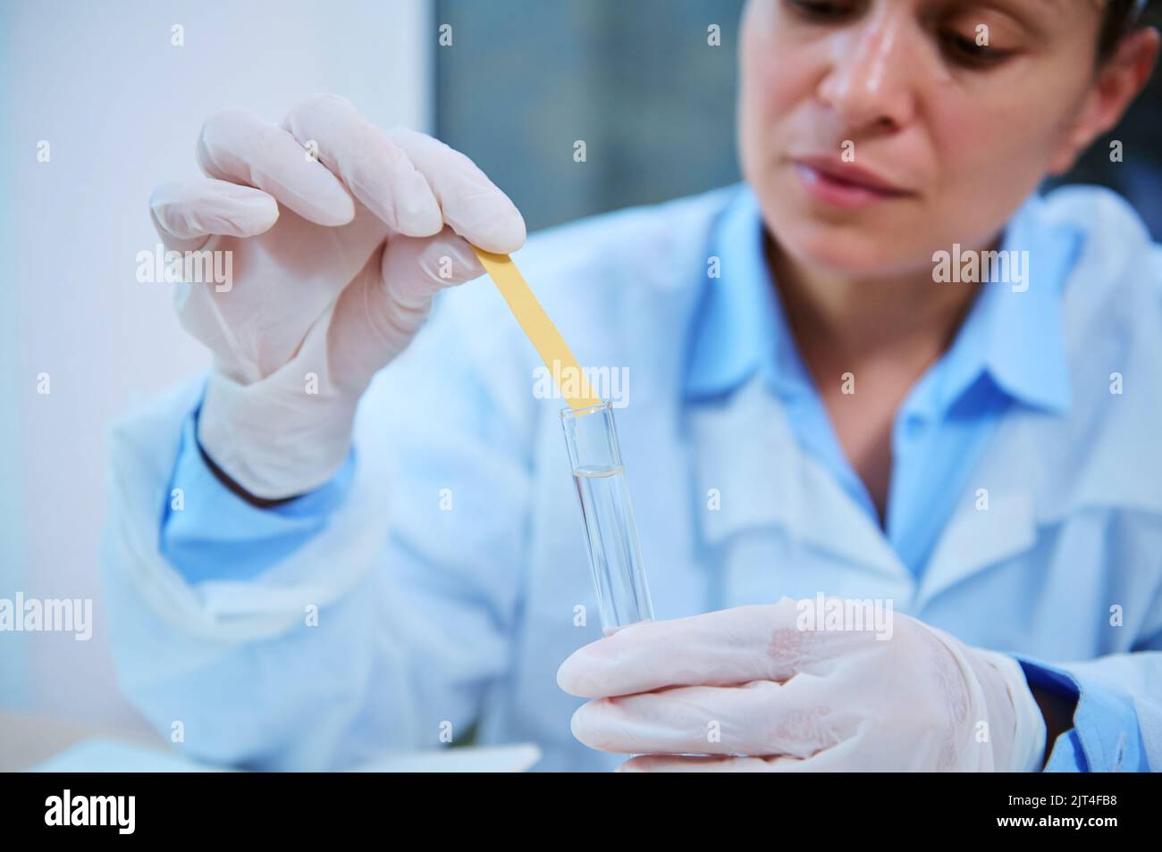 Environmental pollution. Chemist examining sample of contaminated water ...