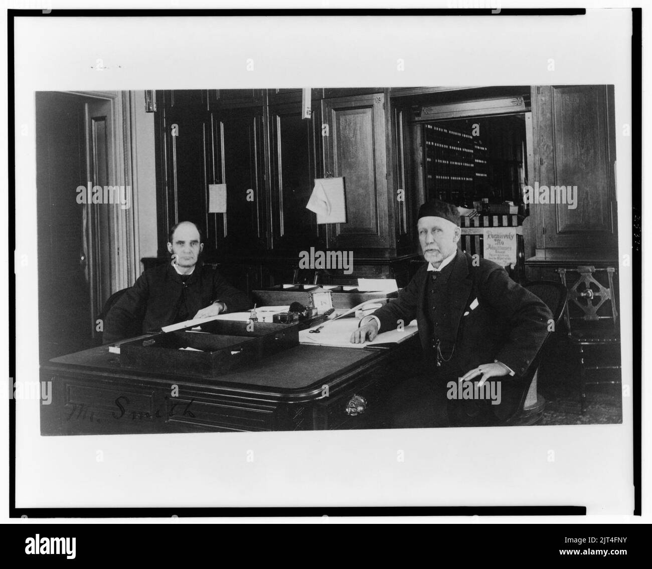 Two Treasury Department employees seated at desk in office Stock Photo ...