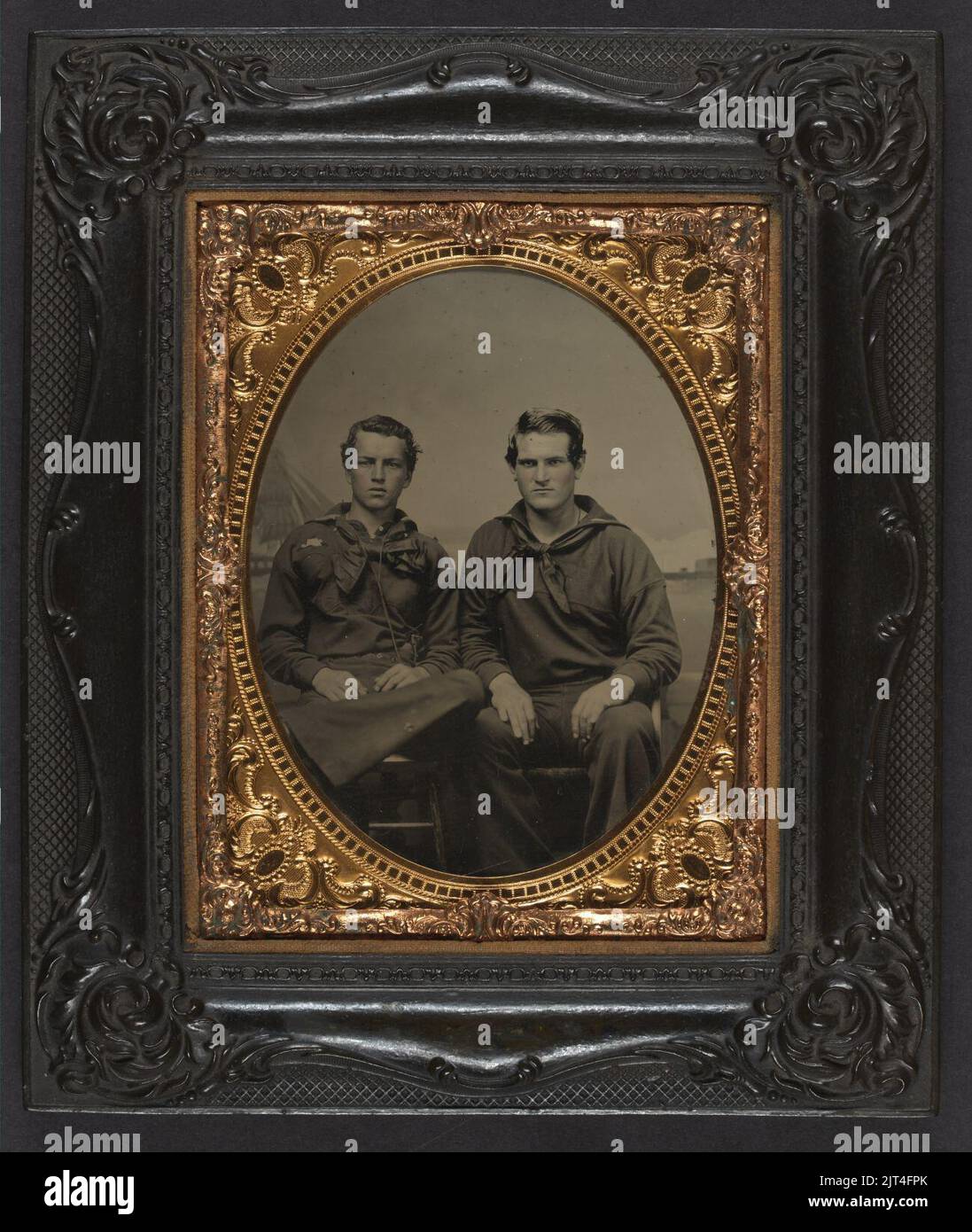 Two unidentified sailors in Union uniforms in front of painted backdrop ...