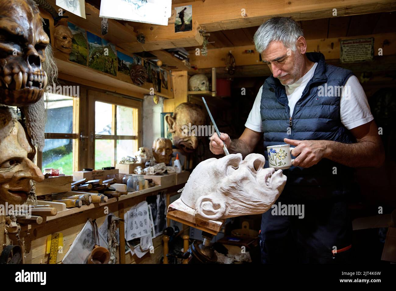 Wood carver manufacturing traditional Krampus wooden mask in ...