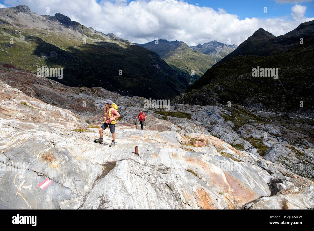 Mother and son hiking over colorful rocks on a glacier moraine on a ...