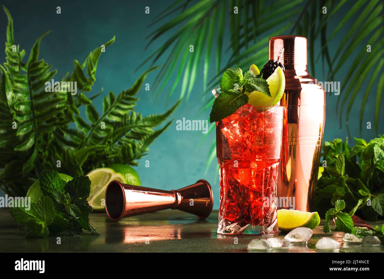 Red alcoholic cocktail with bitter, whiskey, soda, lime, mint and ice ...