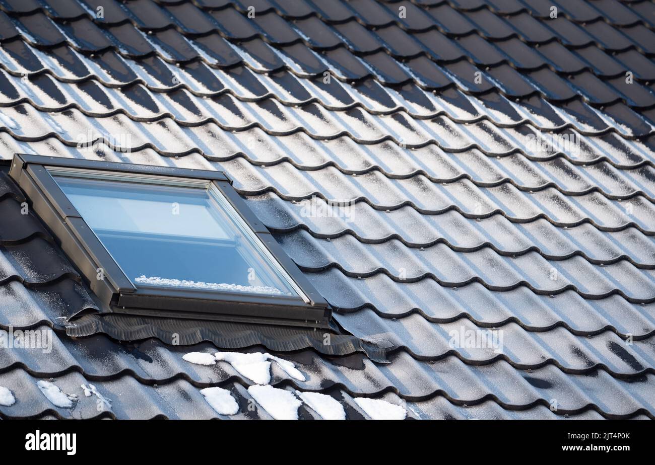 The roof with a window is covered with frost. Negative temperature and ...