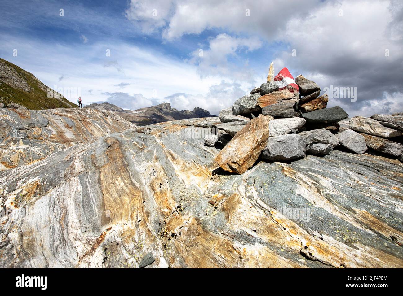 Woman hiking over colorful rocks on a glacier moraine on a beautiful ...