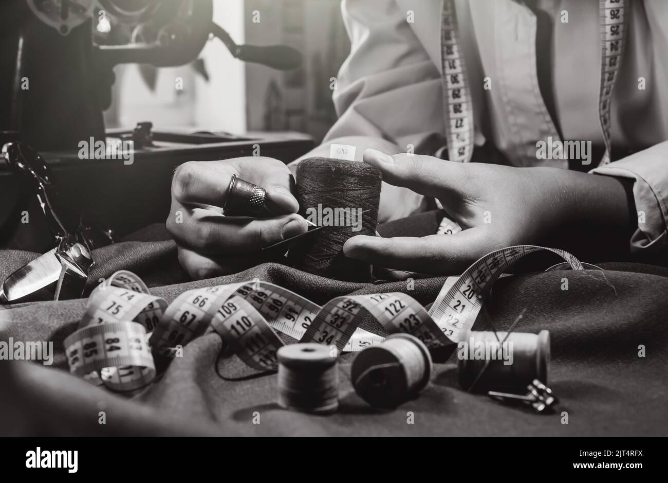 The tailor's hands sew clothes with a needle and thread. Tools for a ...