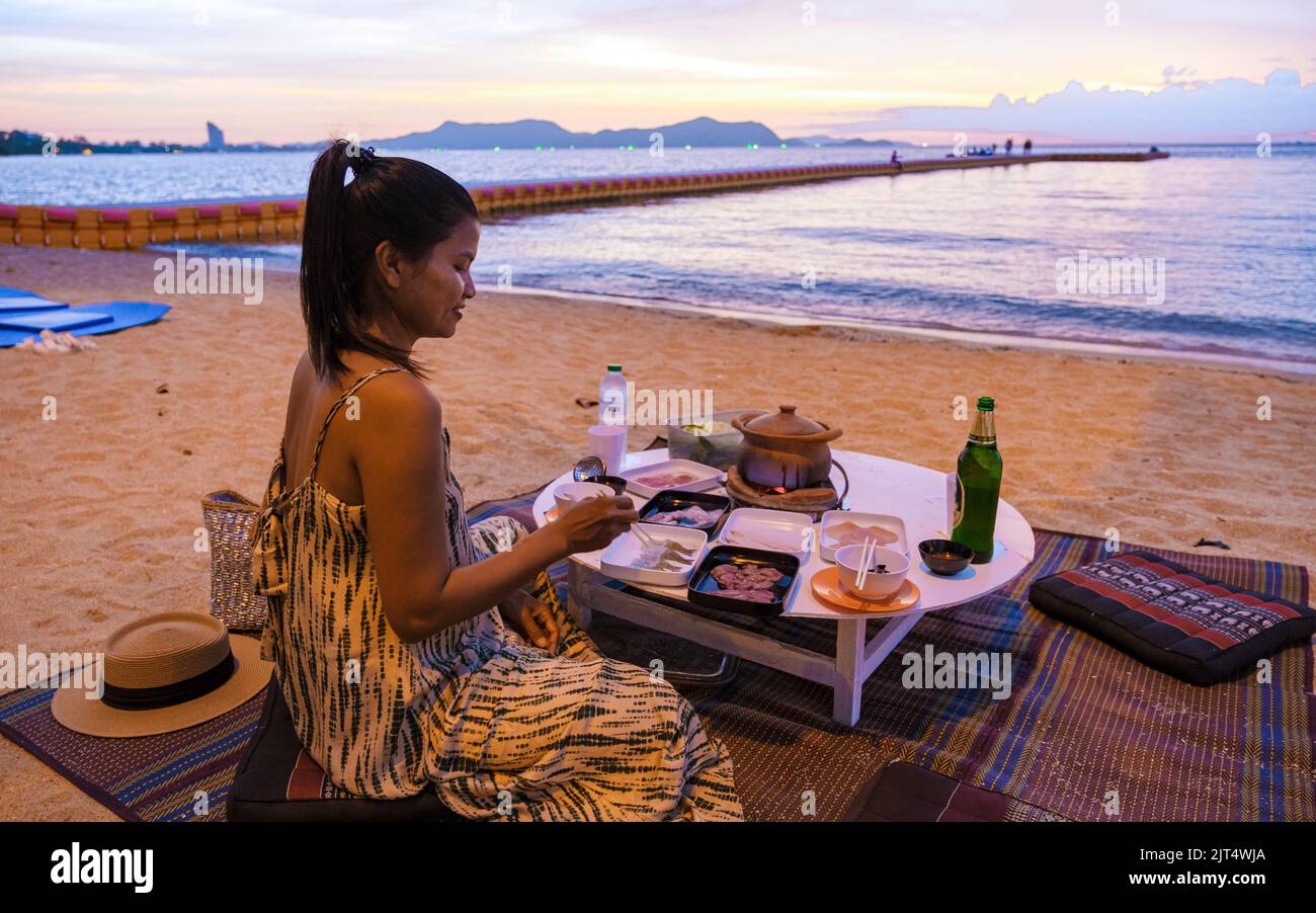 women bbq cooking noodle soup during sunset in Thailand Ban Amphur ...