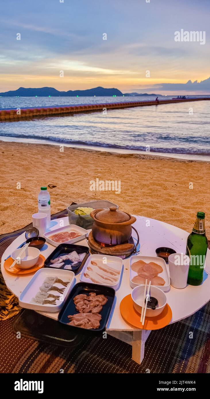 women bbq cooking noodle soup during sunset in Thailand Ban Amphur ...